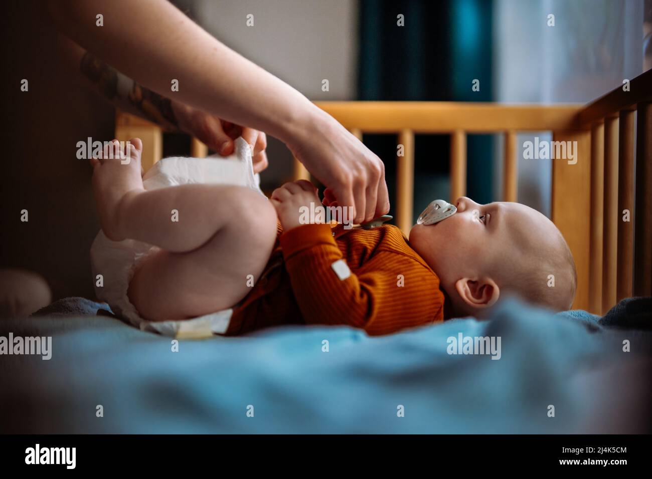 Hand gives baby boy with blue eye a pacifier Stock Photo - Alamy