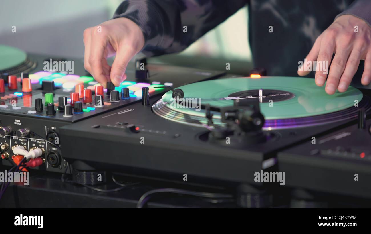 DJ's hands on the mixing console close-up. ART. The DJ is playing a ...
