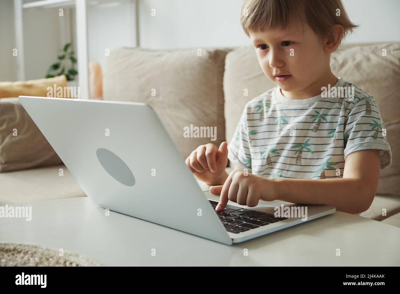 Home schooling, distance learning, Child using laptop while sitting on ...