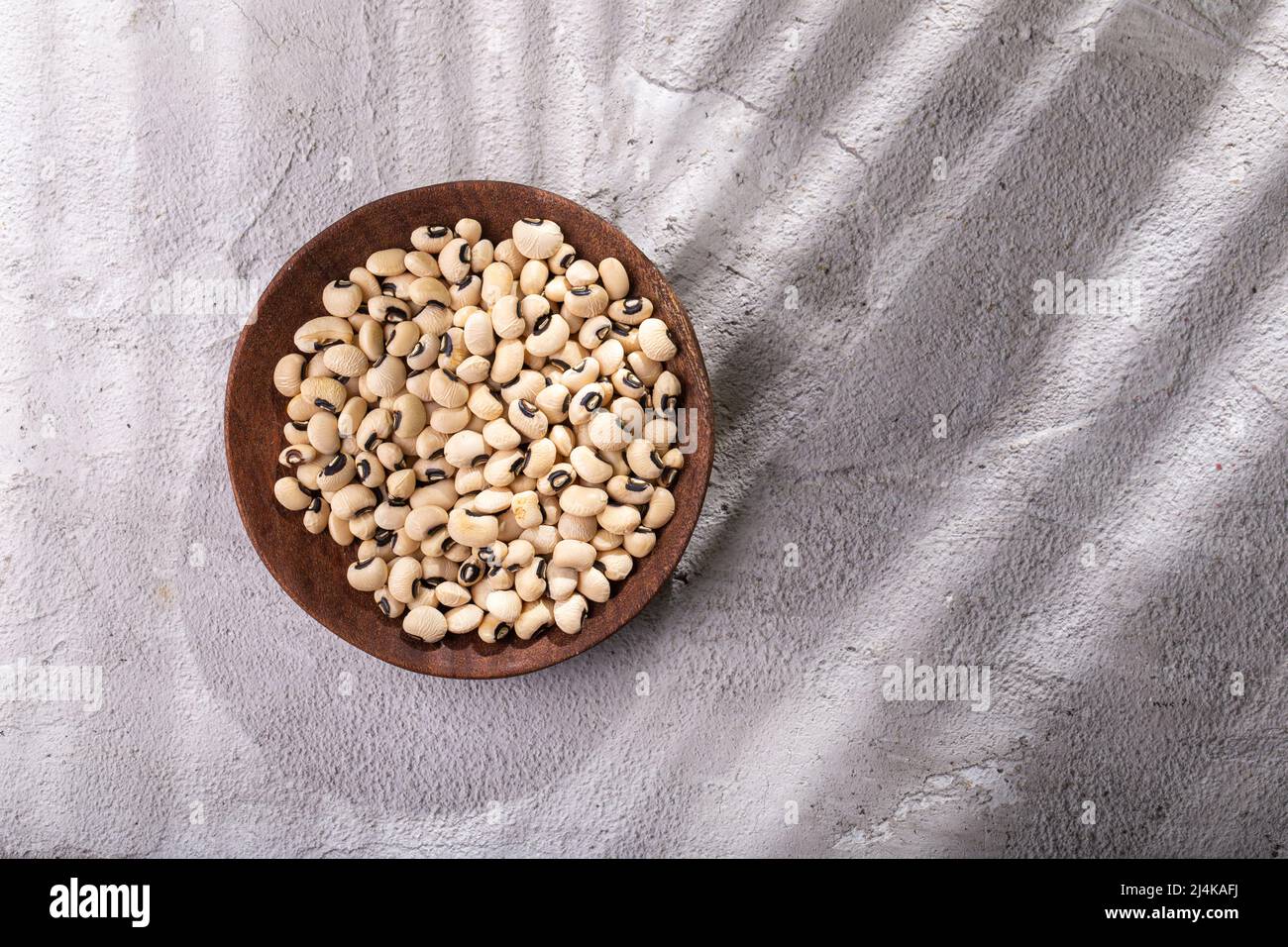pile of black-eyed beans, in container on concrete surface- lubiya ...