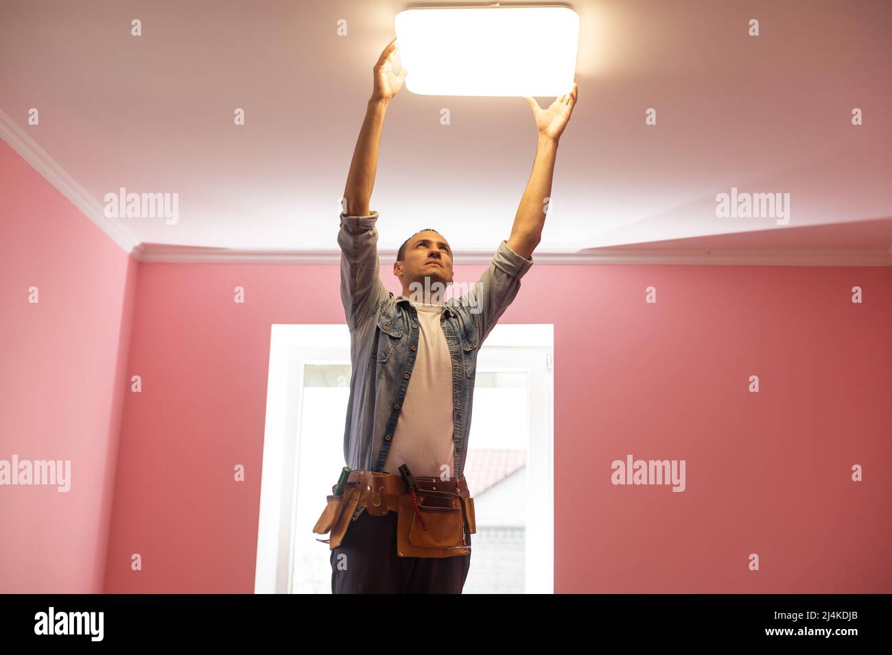Electrician checking lighting to the ceiling in the home, technician ...