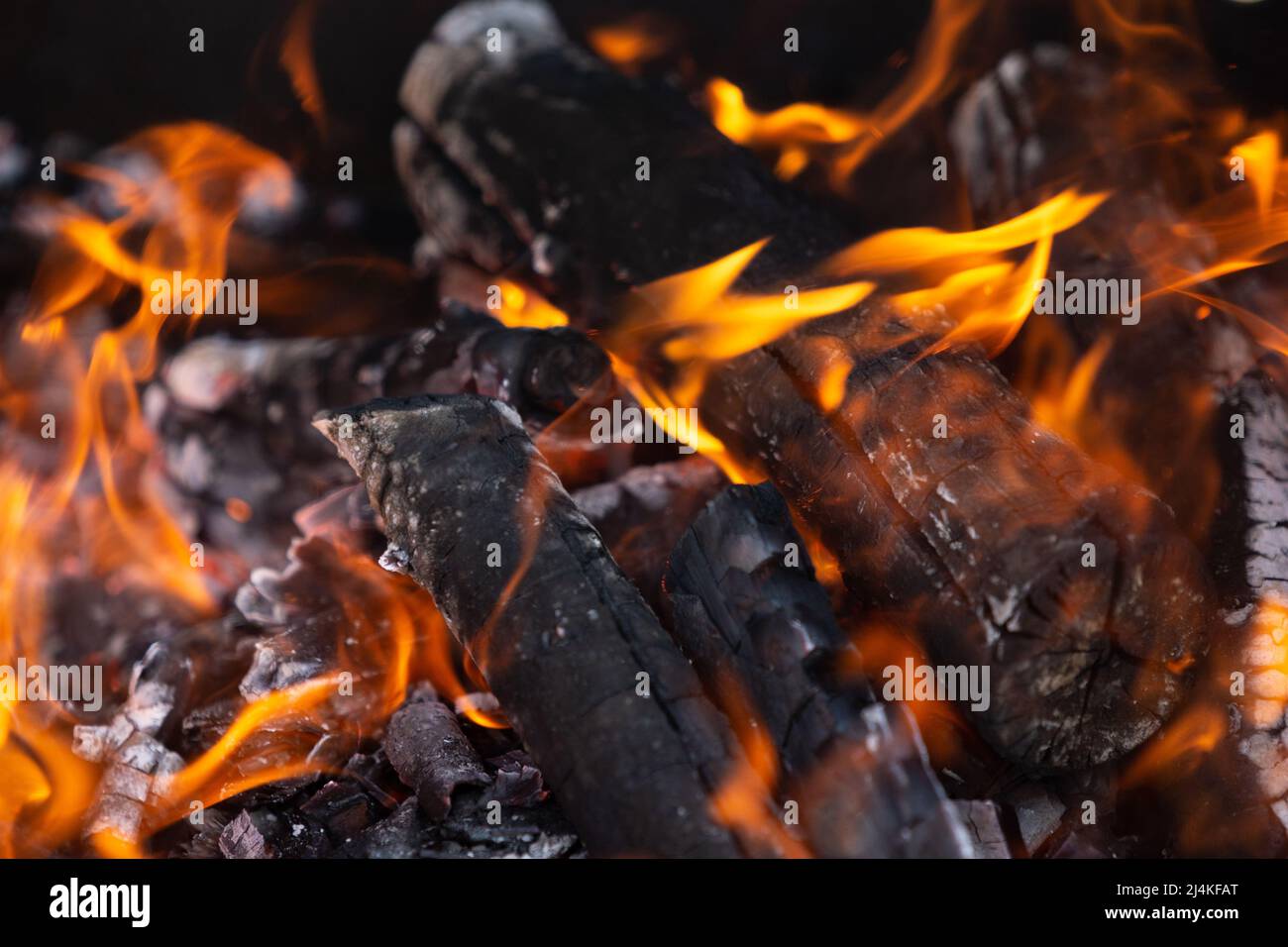 Yellow tongues of flame are dancing on wooden logs Stock Photo - Alamy
