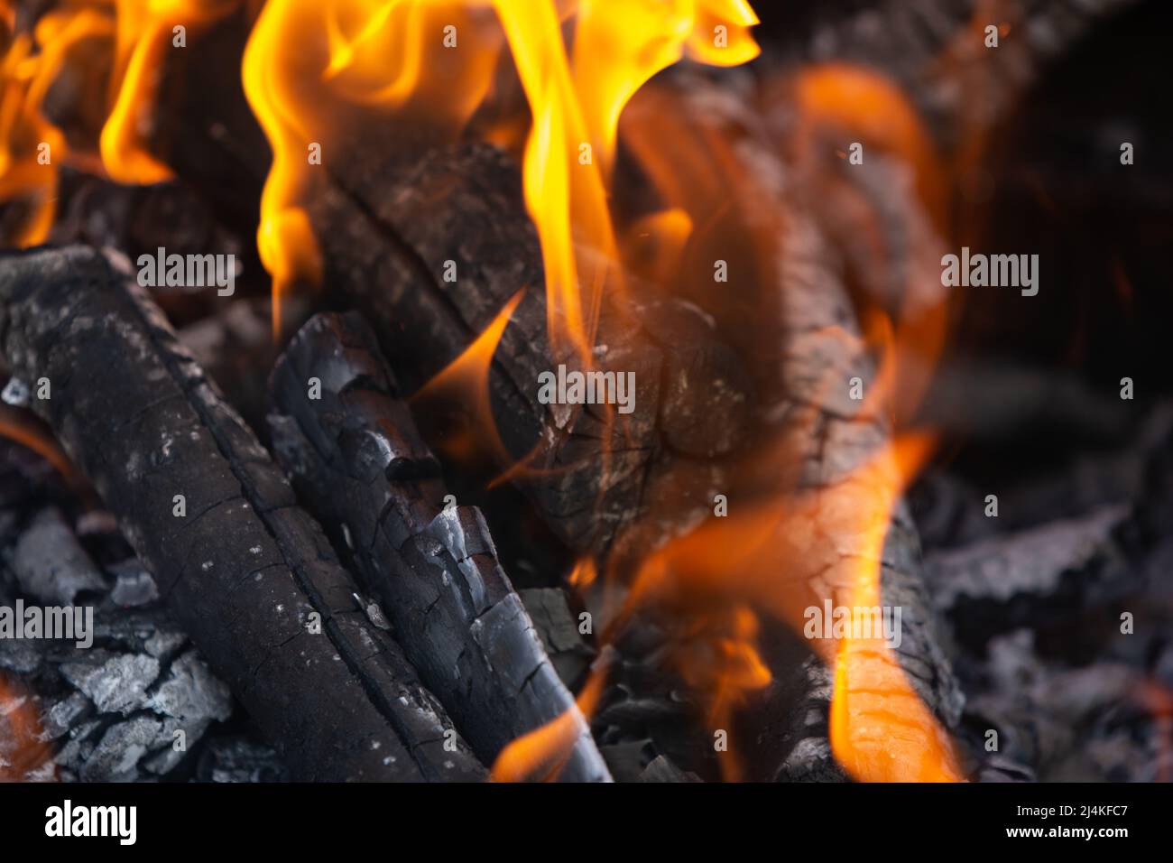 Yellow tongues of flame are dancing on wooden logs Stock Photo - Alamy