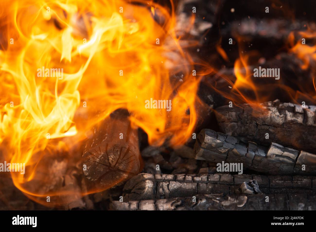 Yellow tongues of flame are dancing on wooden logs Stock Photo - Alamy