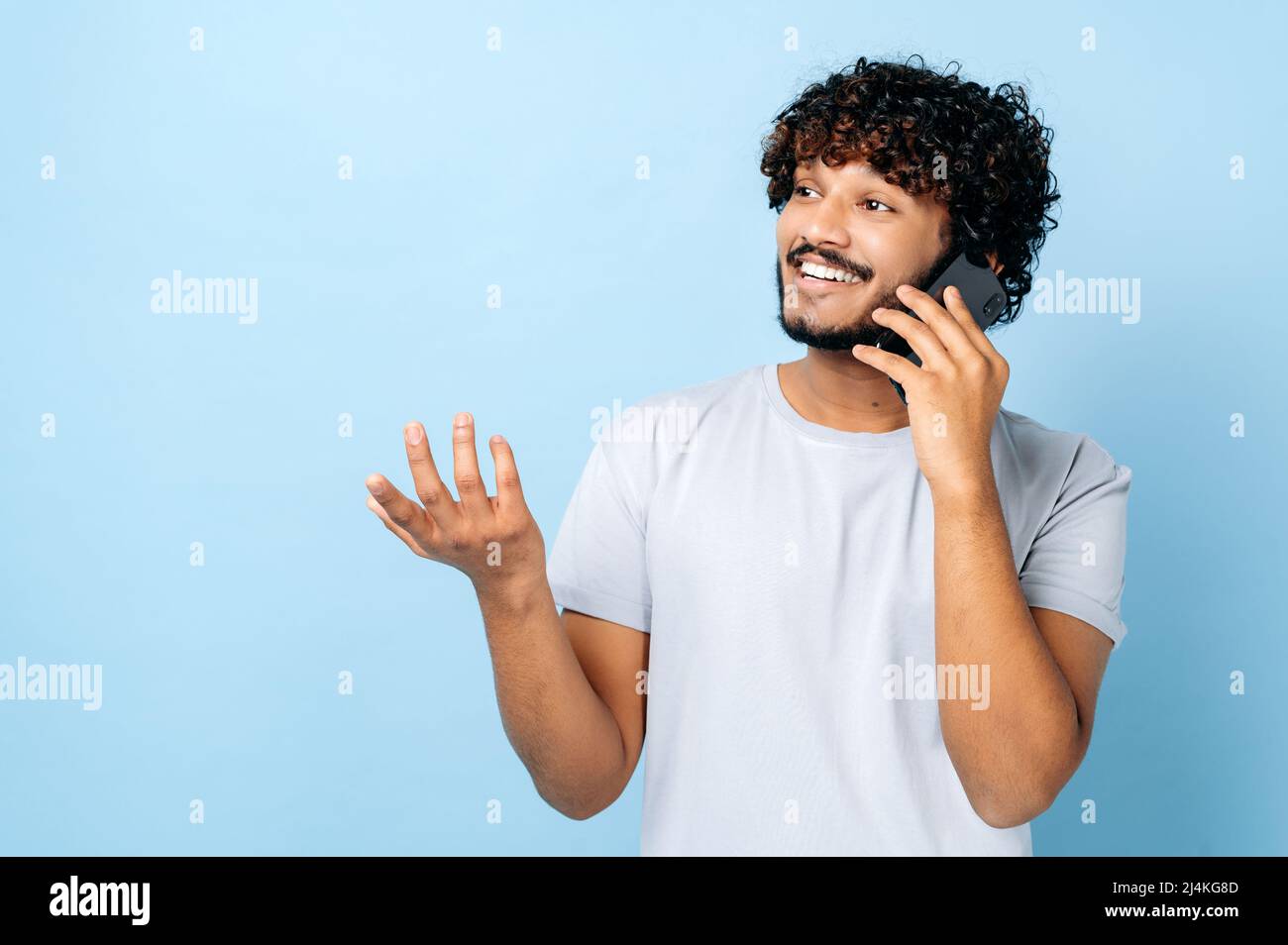 Cellphone conversation concept. Happy arabic or indian attractive guy ...