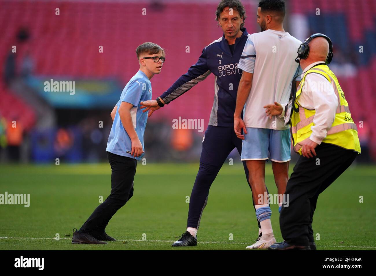 A young Manchester City fan gets onto the pitch to try and get a photo ...