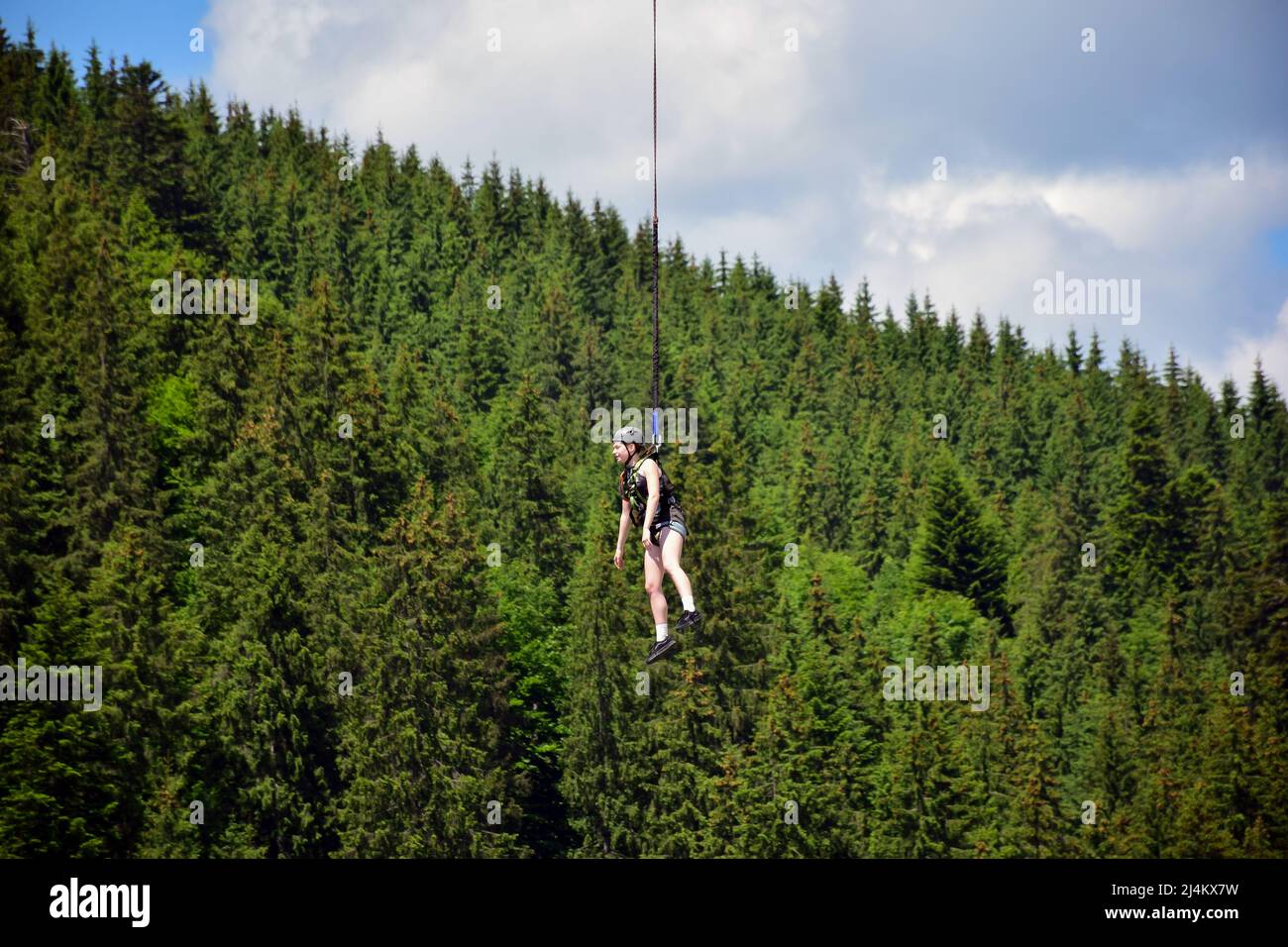 The girl jumped from the bungee jumping ride, hangs on a tight rope at ...
