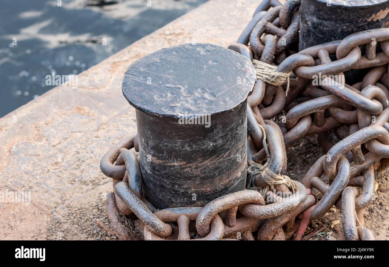 Old rustic anchor pillar on the river close up shot Stock Photo - Alamy