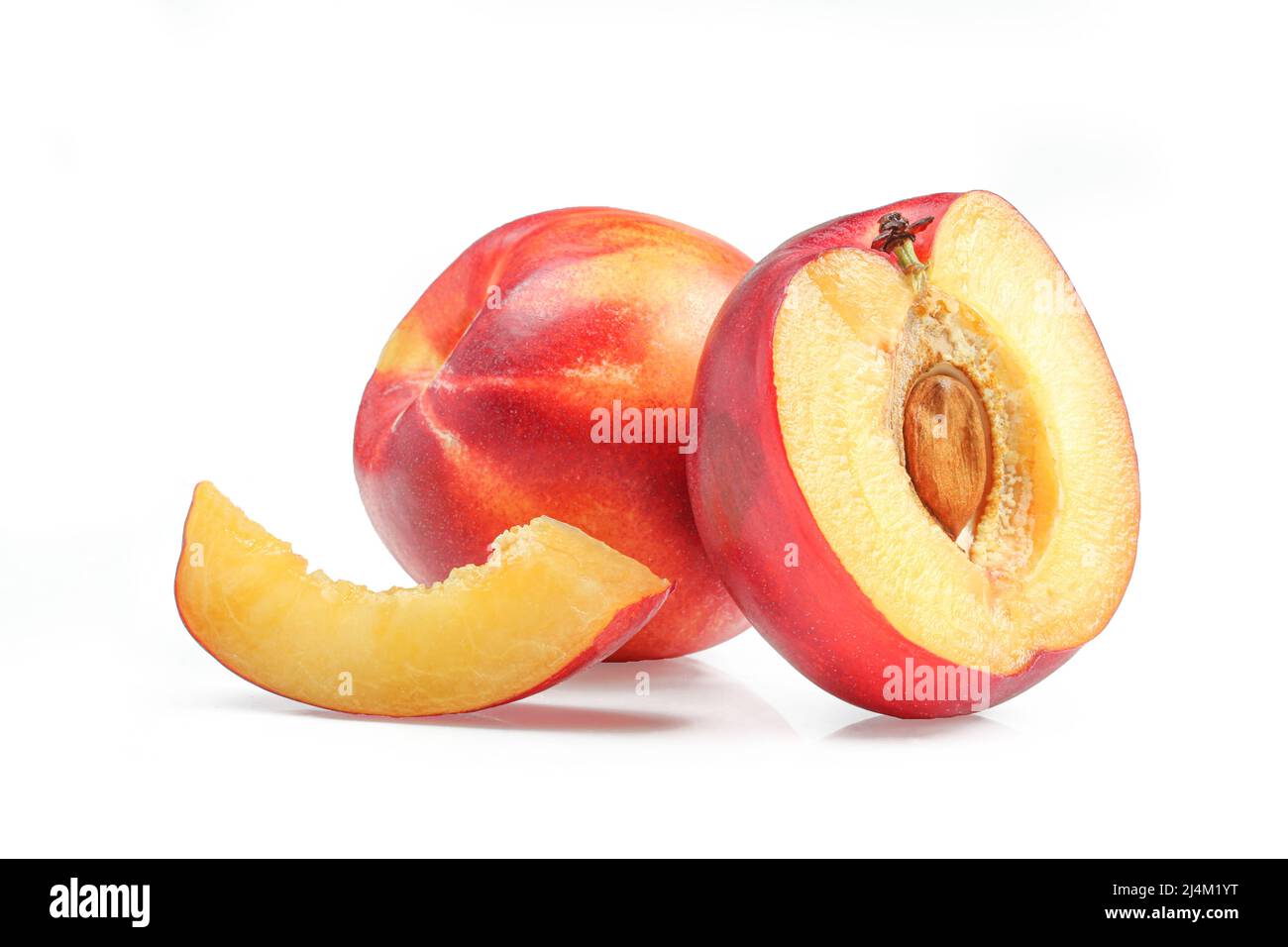 Whole and sliced nectarine with visible seed core isolated on white ...