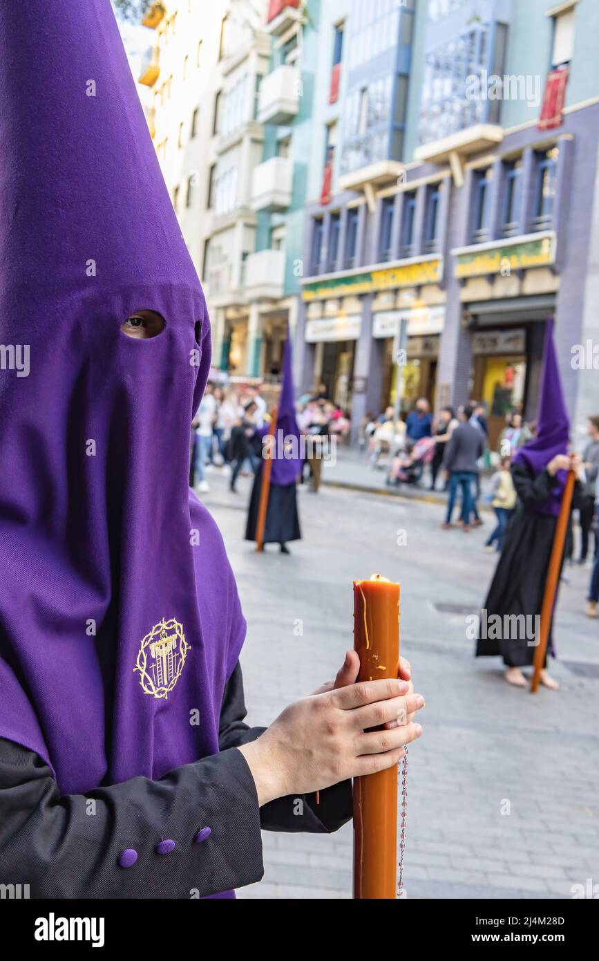 The candle in flame of a young Nazarene with a rosary to pray in her ...