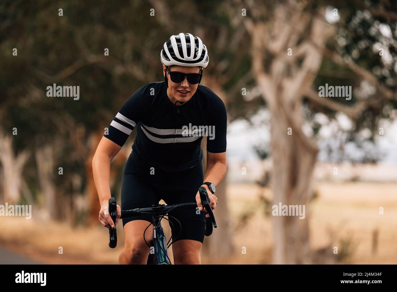 Professional female cyclist doing intense ride out of the saddle on ...