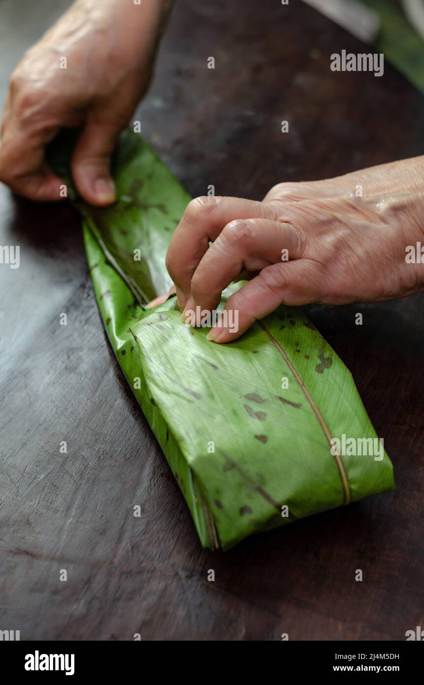 Native woman cooking traditional Colombian dish made with corn dough ...