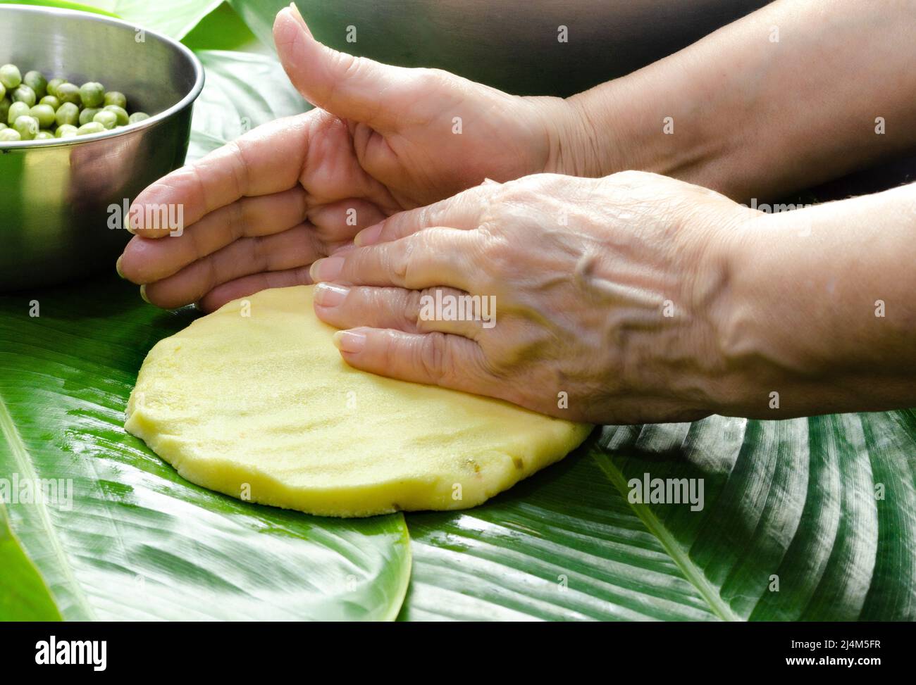 Native woman cooking traditional dish Colombian made with corn dough ...