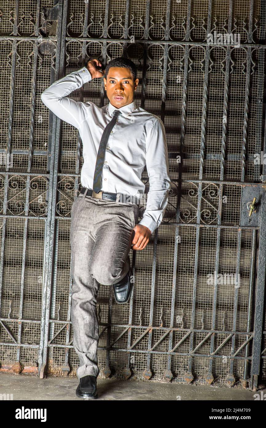 Wearing a white shirt, a black tie, gray pants, leather shoes, a young ...