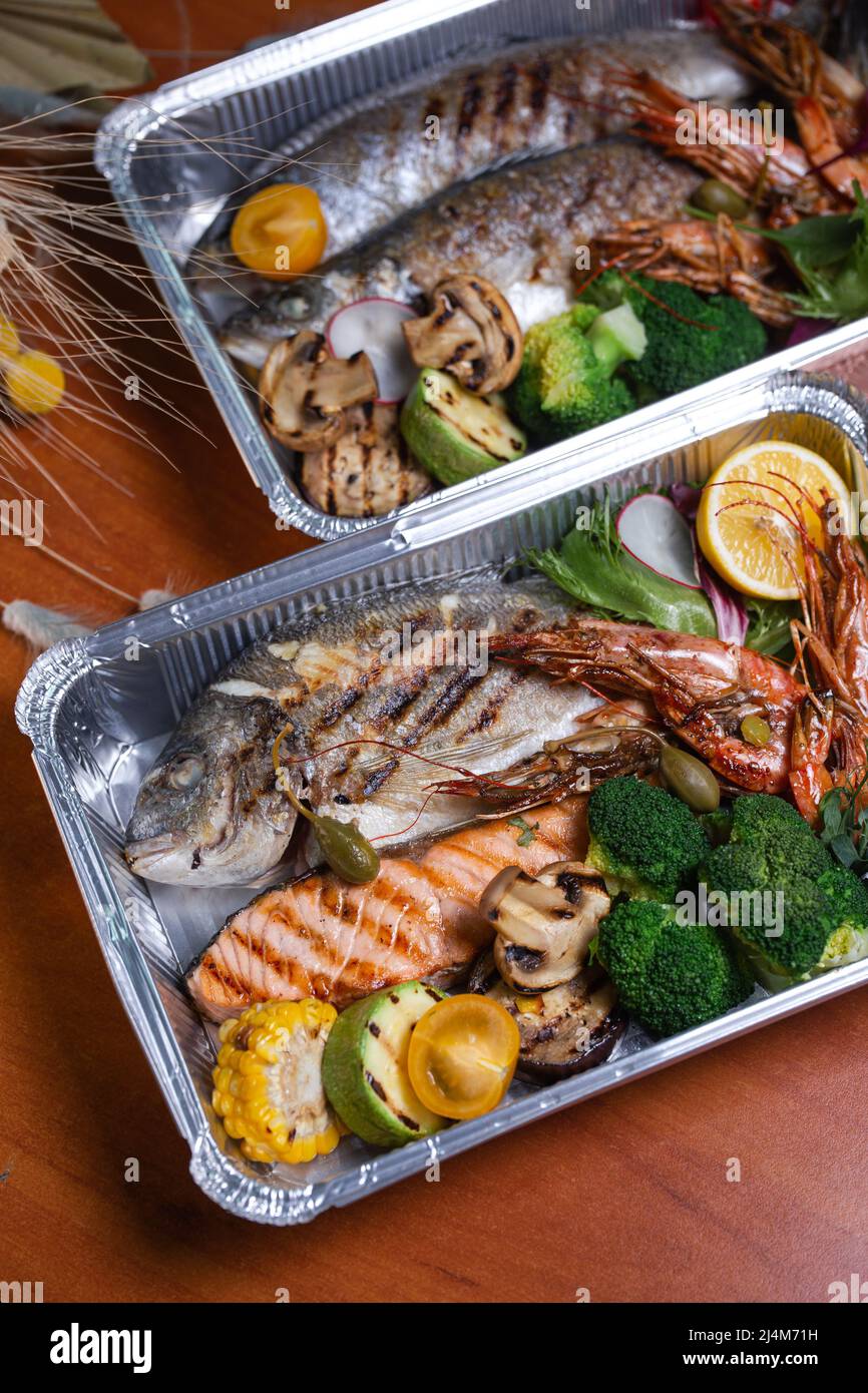 top view fish set with shrimp and broccoli in a delivery dish Stock ...