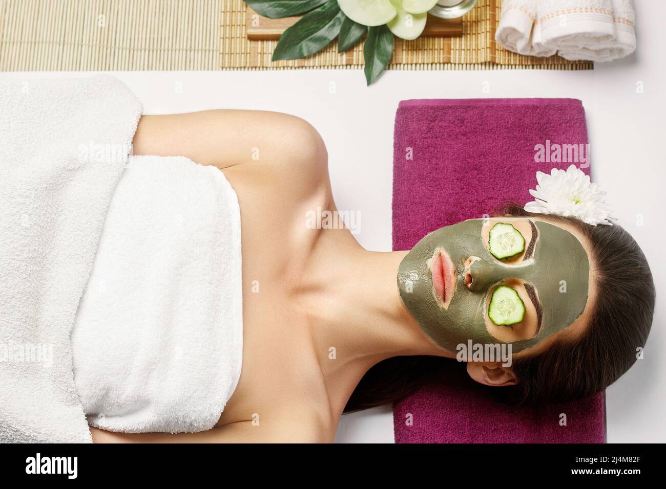 Spa Clay Mask. Woman with clay facial mask and cucumbers on eyes in ...