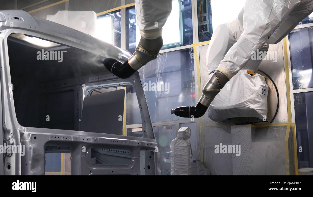 Robotic technology paints body of car. Scene. Robotic hands paint car ...