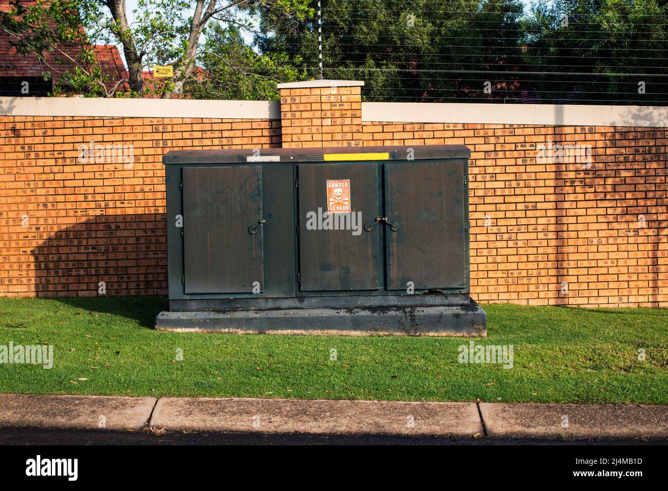 Green transformer box, with a danger sign on a sunny day Stock Photo ...