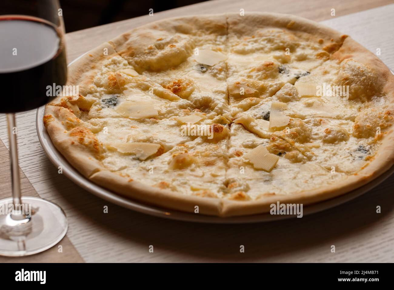 Four cheese pizza quattro formaggi with glass of wine on dark background Stock Photo - Alamy