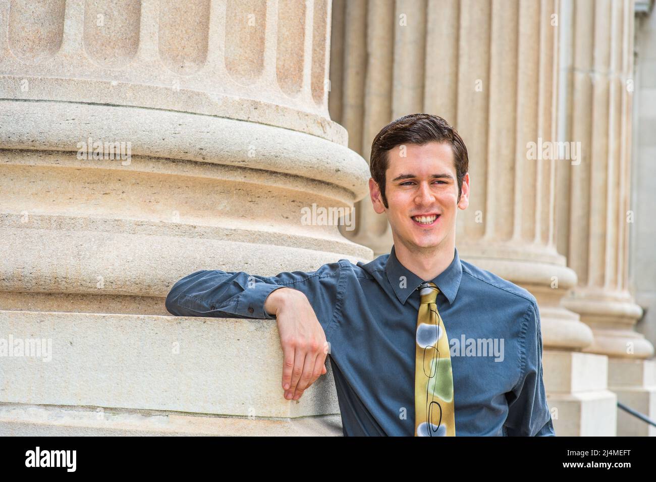 Dressing in a blue shirt, a colorful tie, a young college student is ...