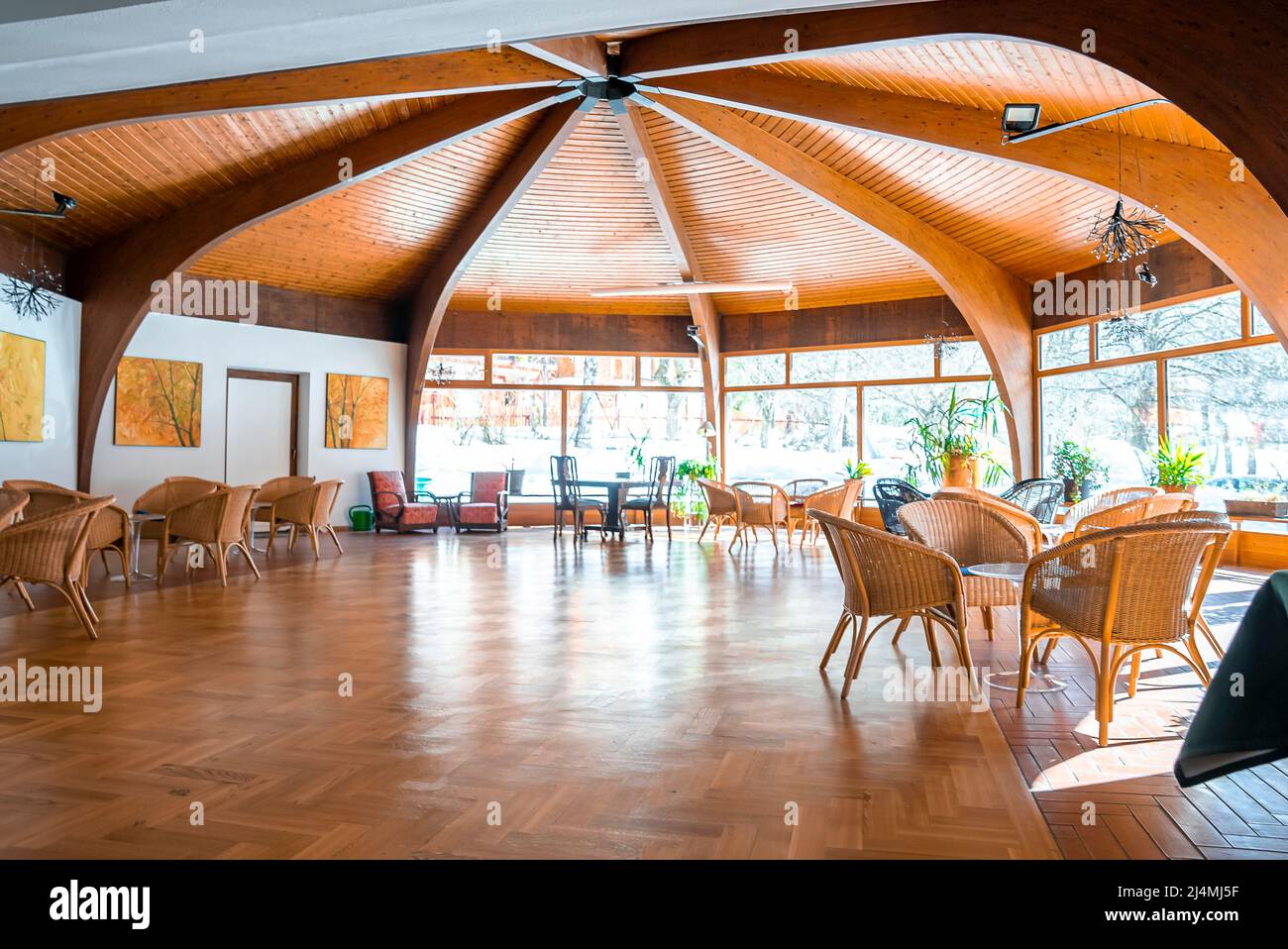 Wooden table setting places with chairs under decor ceiling in modern ...