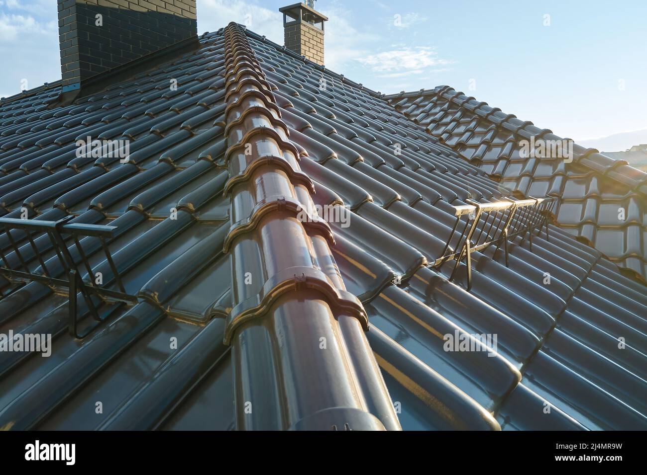 Closeup of house roof top covered with ceramic shingles. Tiled covering ...