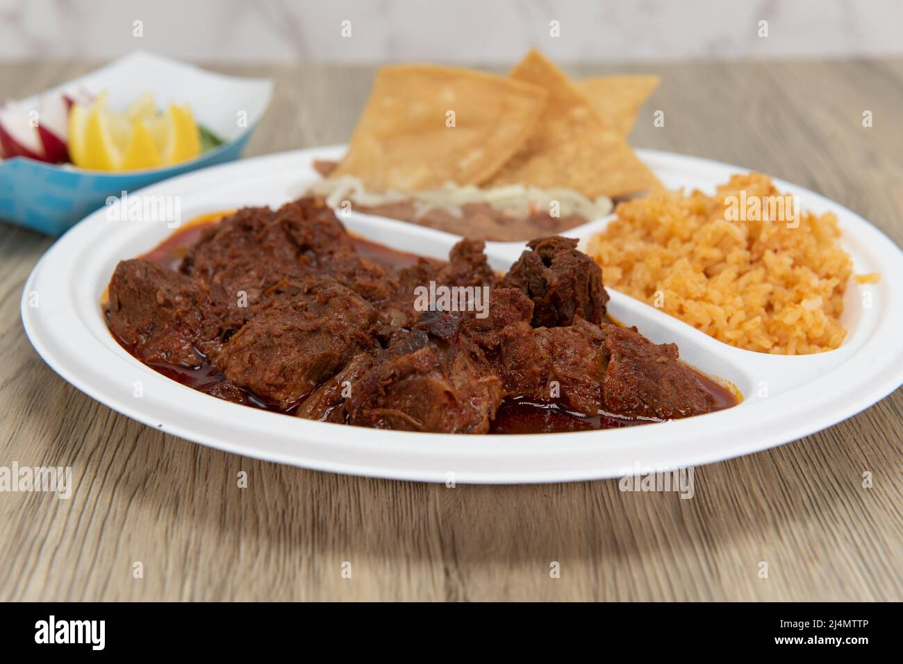 Steak birria stew meat served in gravey with rice and beans as a ...