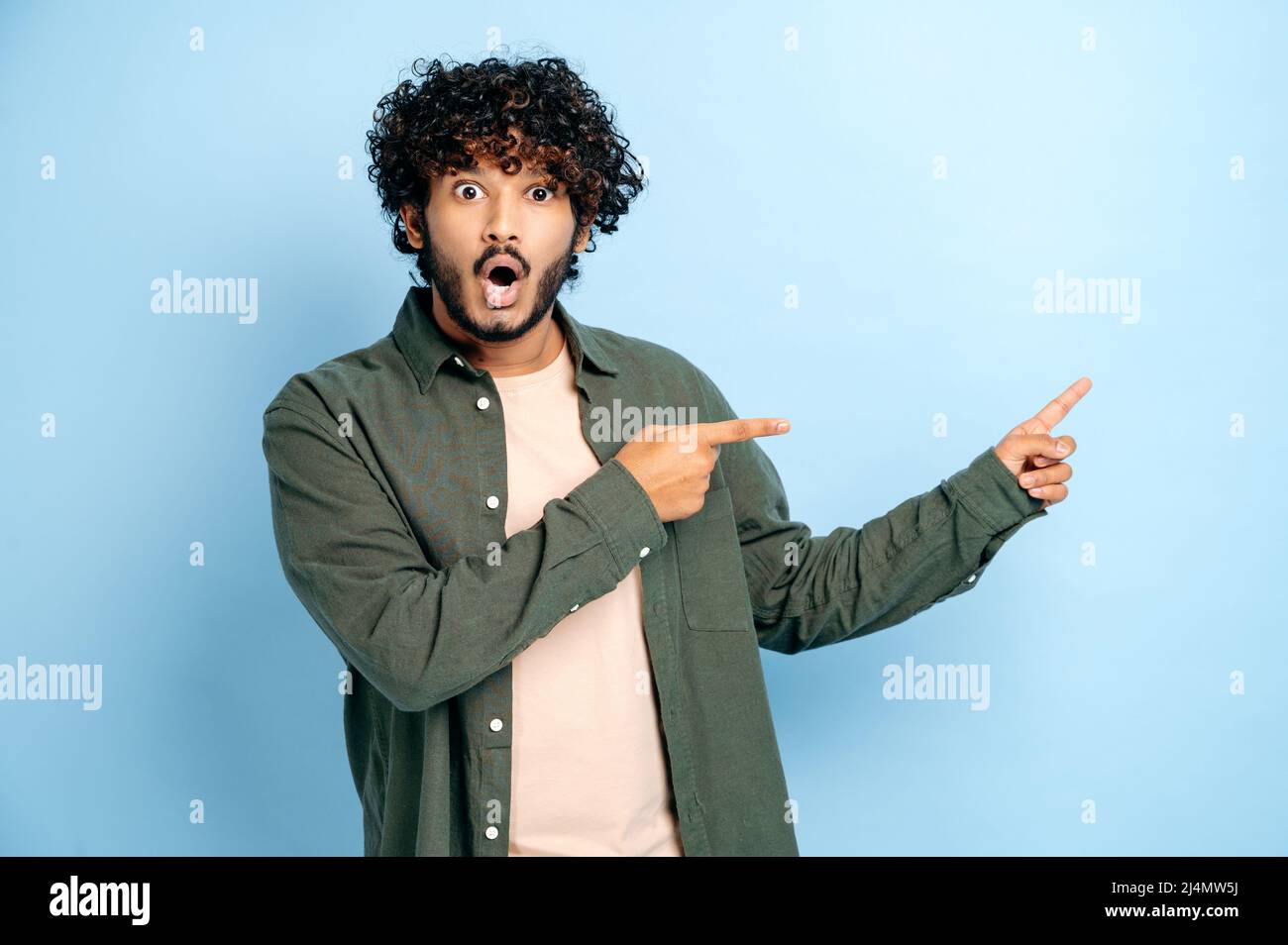 Amazed Shocked Indian Or Arabian Curly Haired Guy In Casual Wear