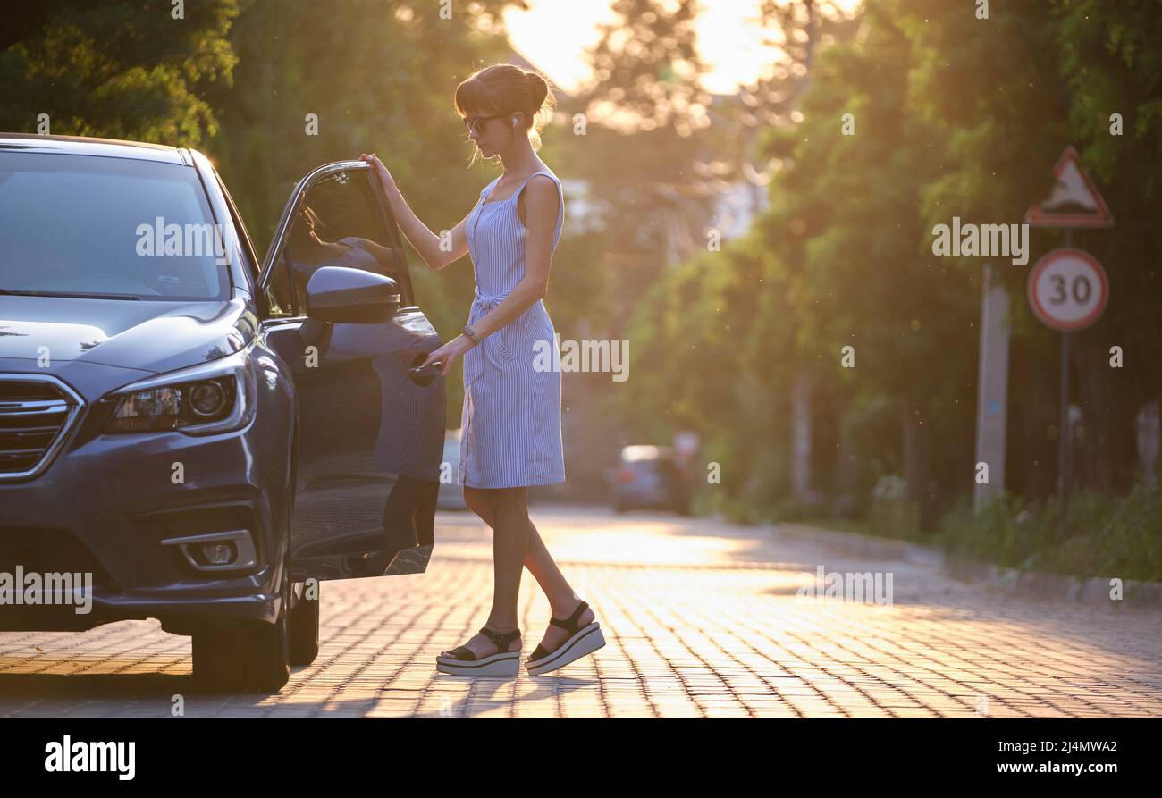 Young woman driver getting inside her car. Transportation and traffic ...