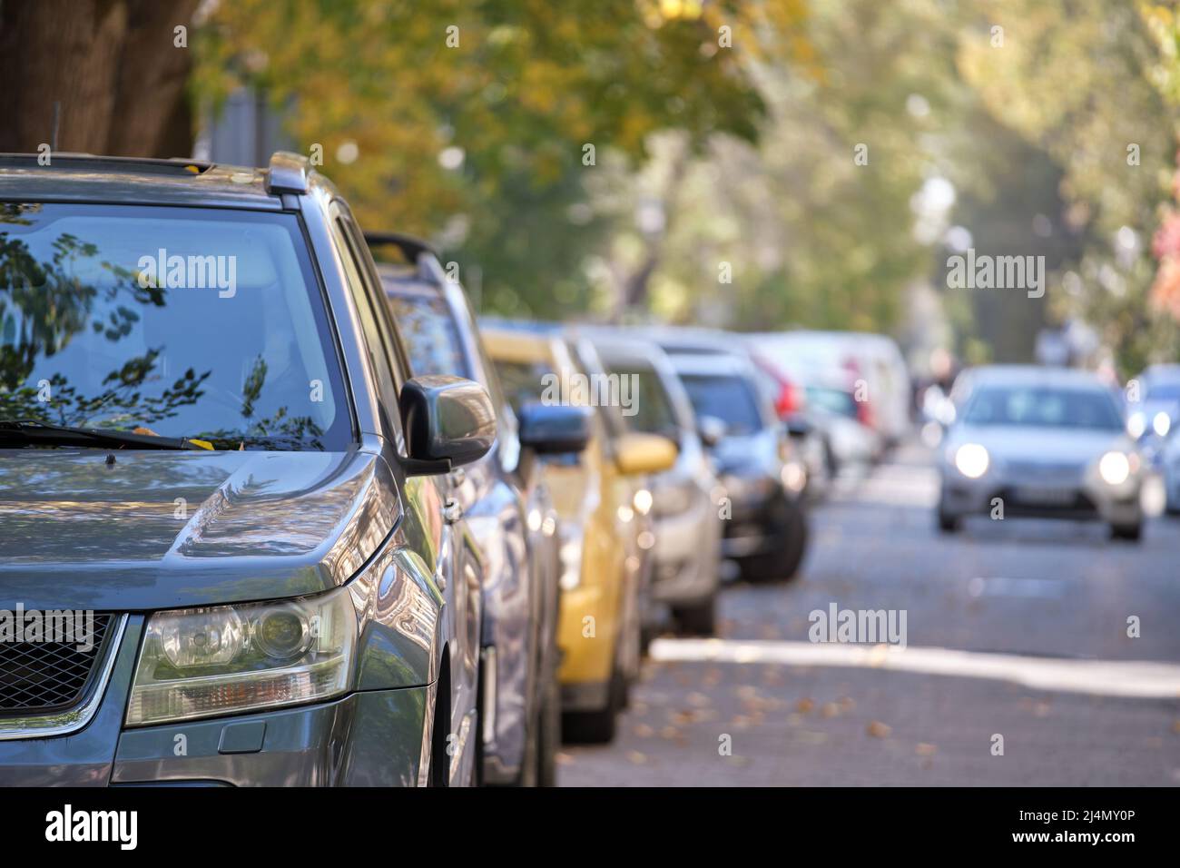 City traffic with many cars parked in line on street side Stock Photo ...