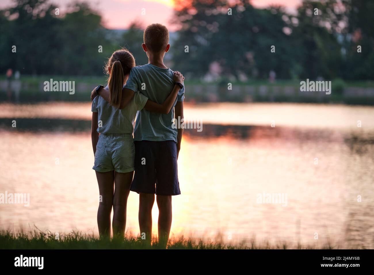 Happy siblings hugging lovingly in summer park. Young children brother ...