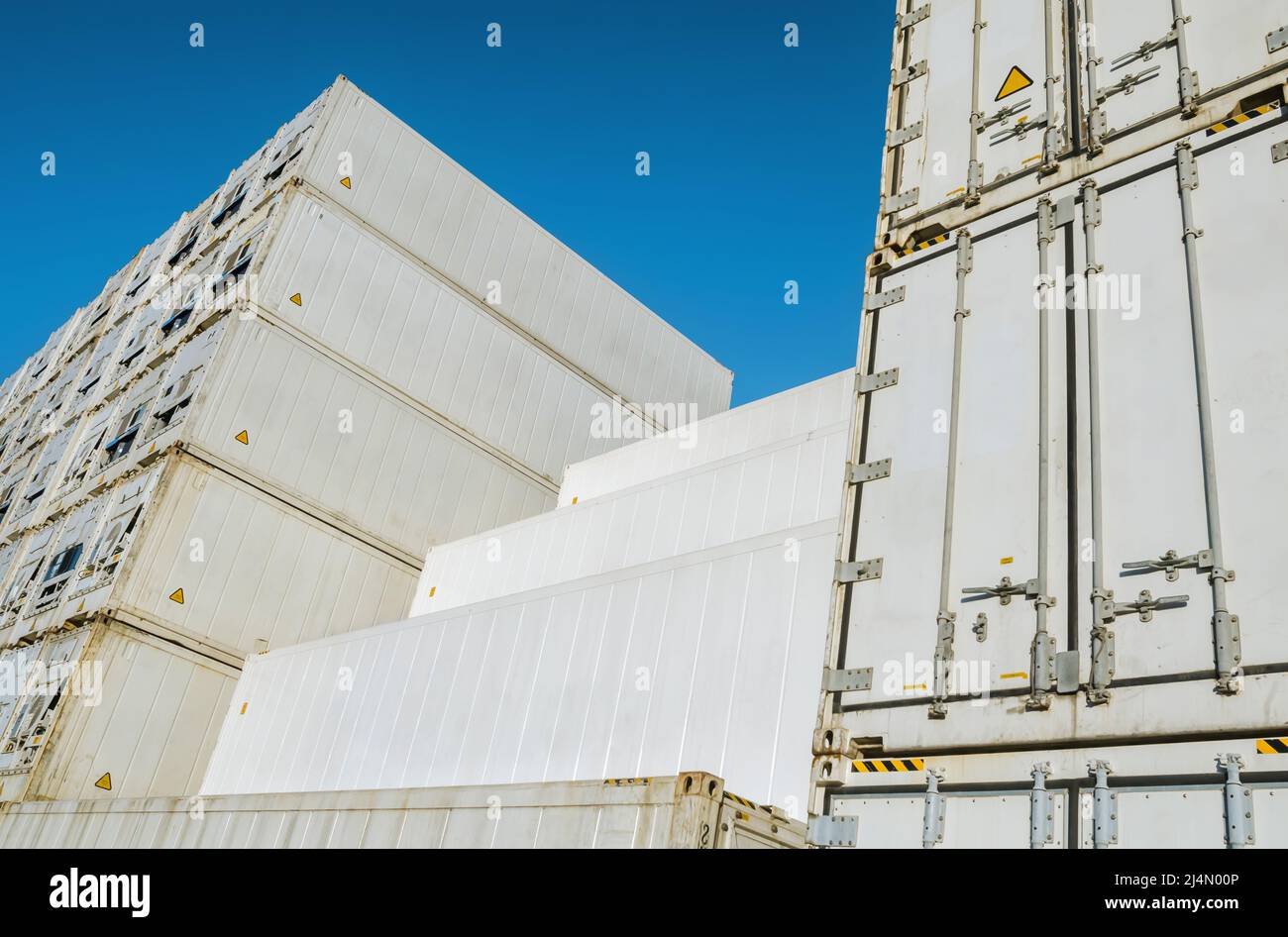 Refrigerated shipping containers stacked high against a blue sky Stock ...