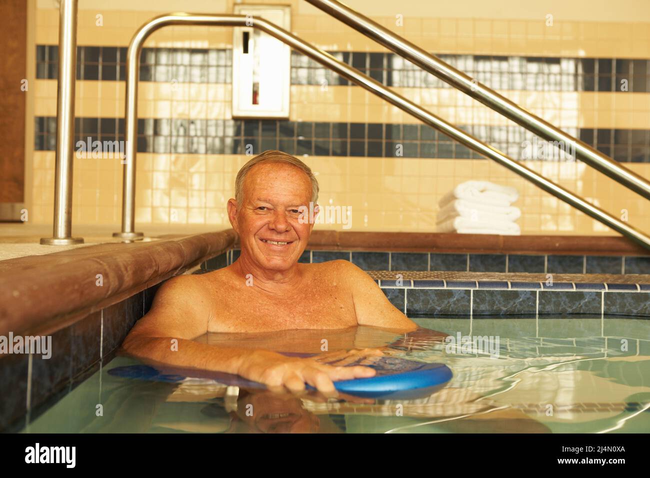 Mature male in hospital pool with flotation device for hydrotherapy ...