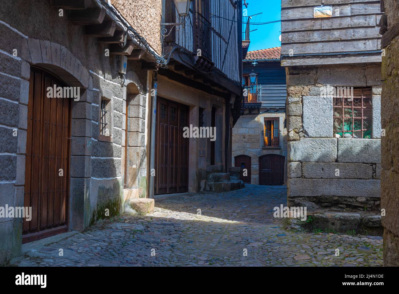 Timber houses alongside a narrow street in La Alberca village in Spain ...
