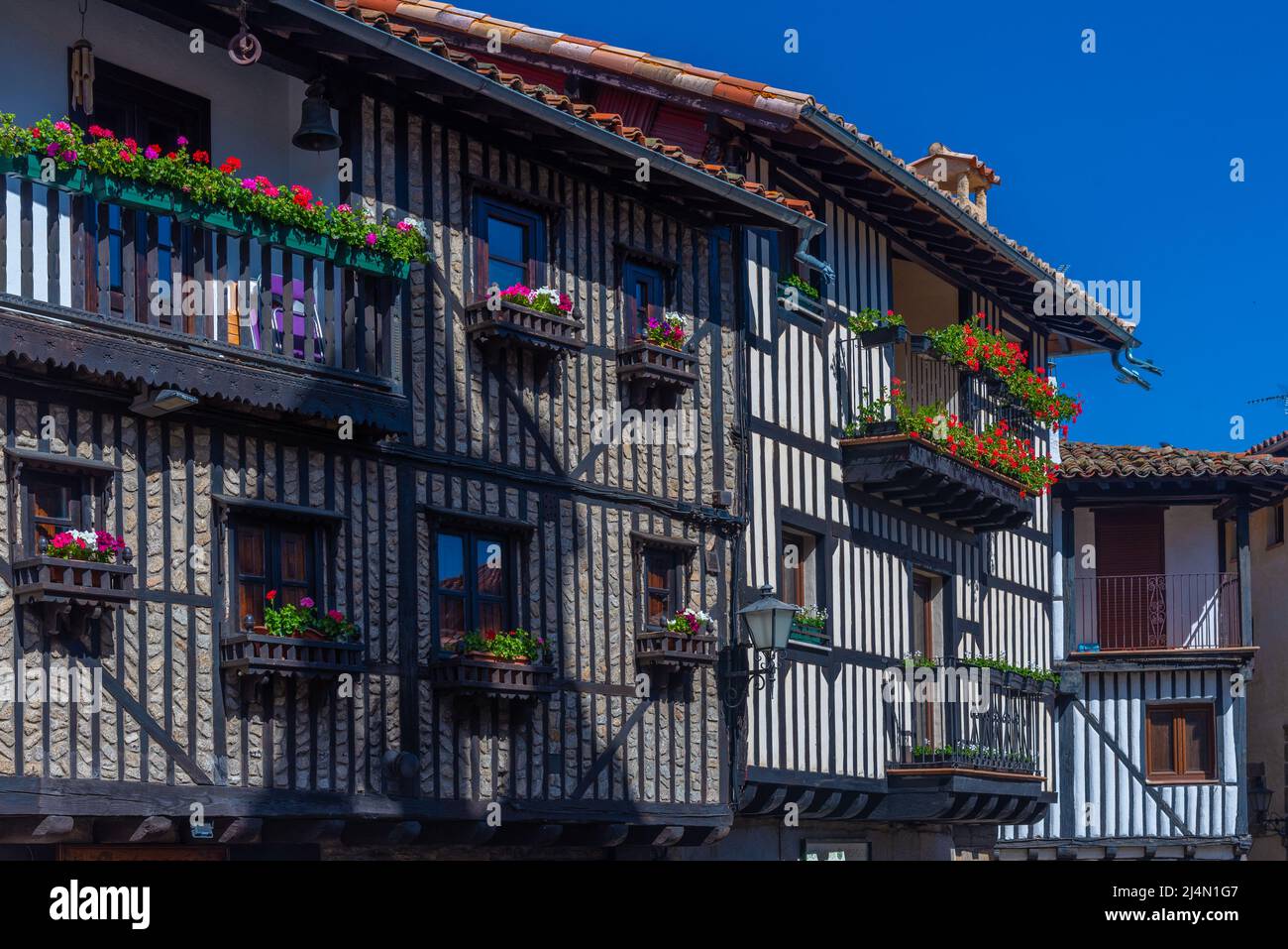 Timber houses alongside a narrow street in La Alberca village in Spain ...