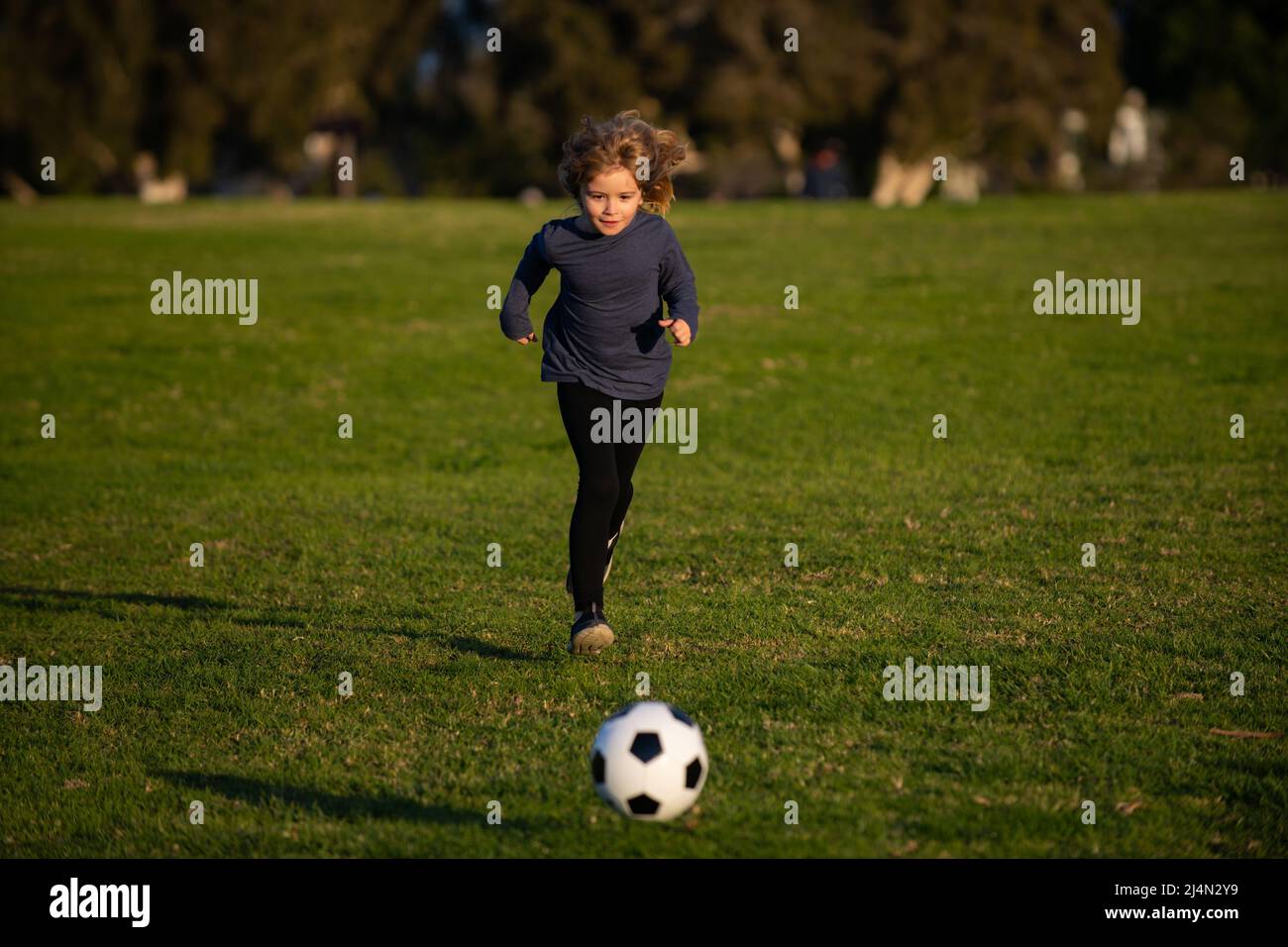 Little boy shooting at goal, kid kicking football ball. Young soccer ...
