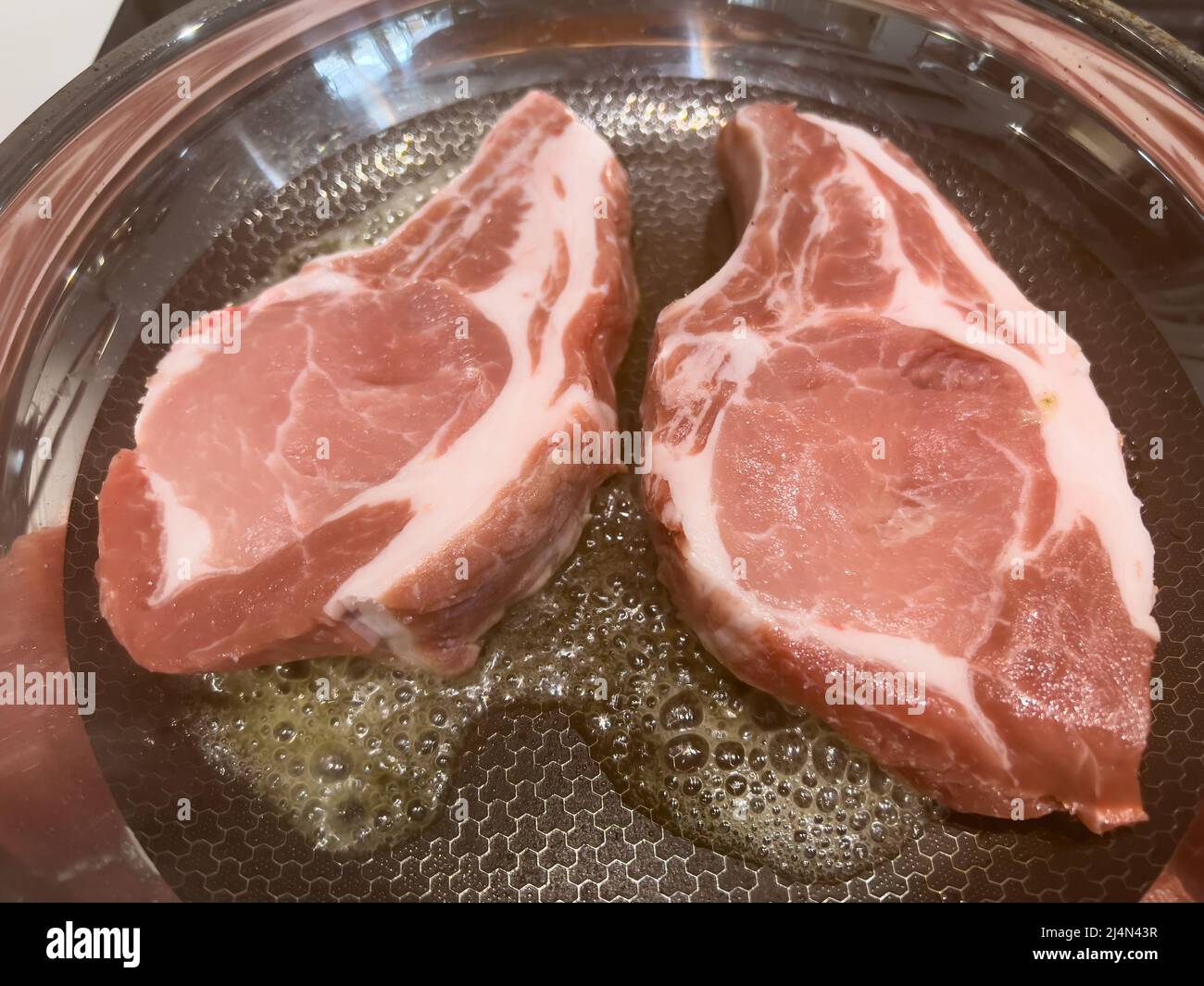 Delicious fresh pork meat with bone slowly cooking in butter in inox ...