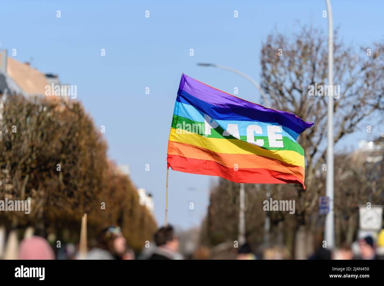 Beautiful rainbow LGBTQI flag waving in the wind with large PEACE word ...