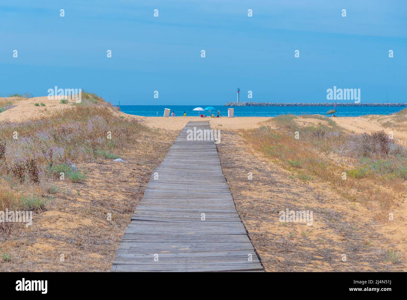 People are enjoying a sunny day on a Mazagon beach near Huelva, Spain ...