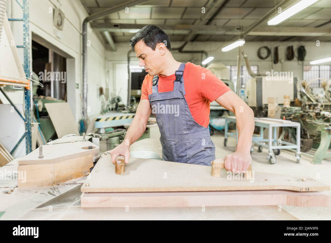 Skillful carpenter cutting wooden board with router Stock Photo - Alamy