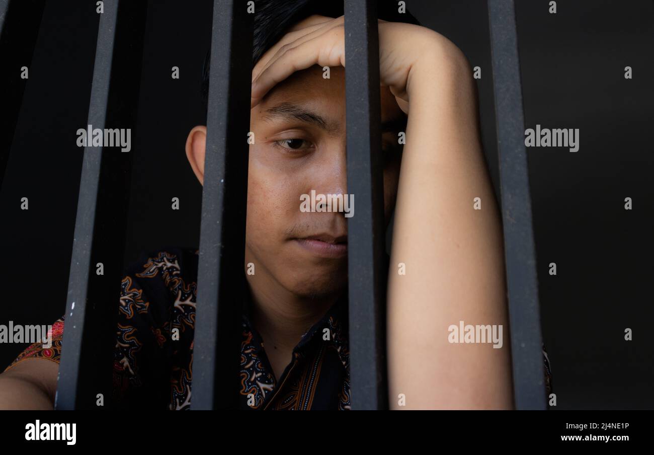 Man standing behind bars holding hi-res stock photography and images ...