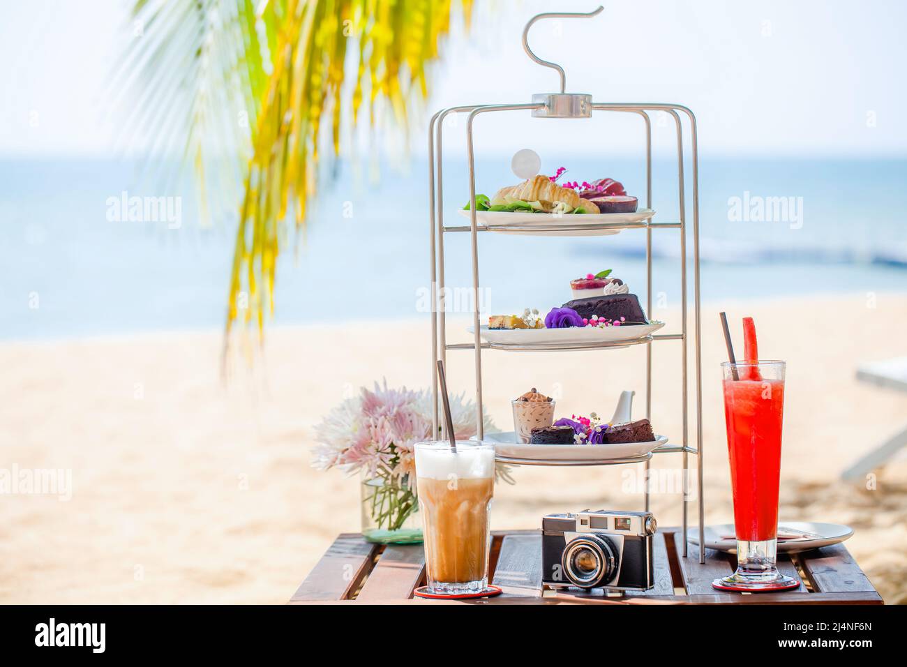 Afternoon tea on tropical sandy beach with blue sea and palm leaf on ...