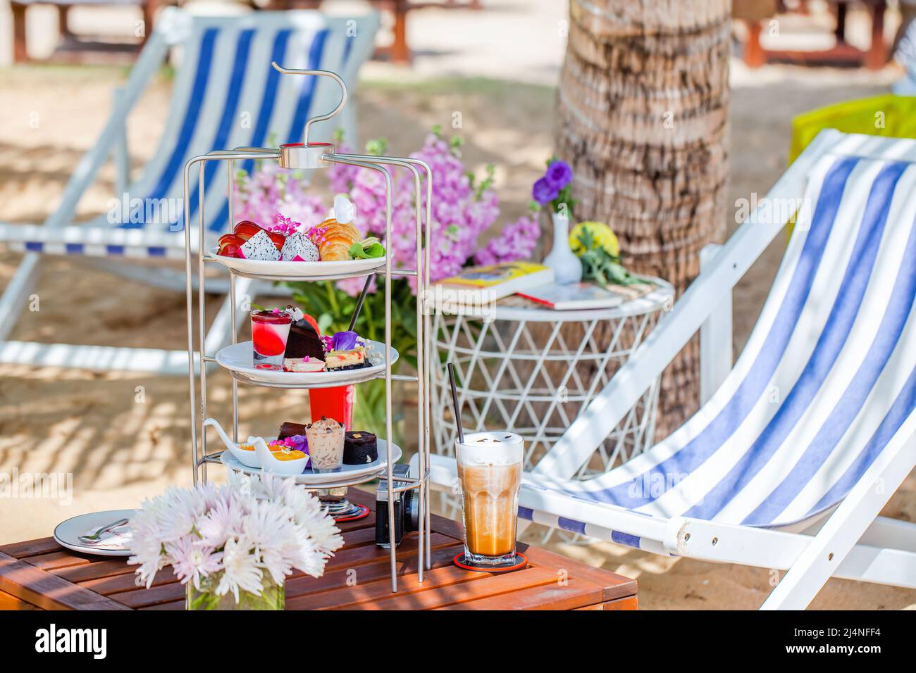 Afternoon tea on tropical sandy beach with blue sea and palm leaf on ...