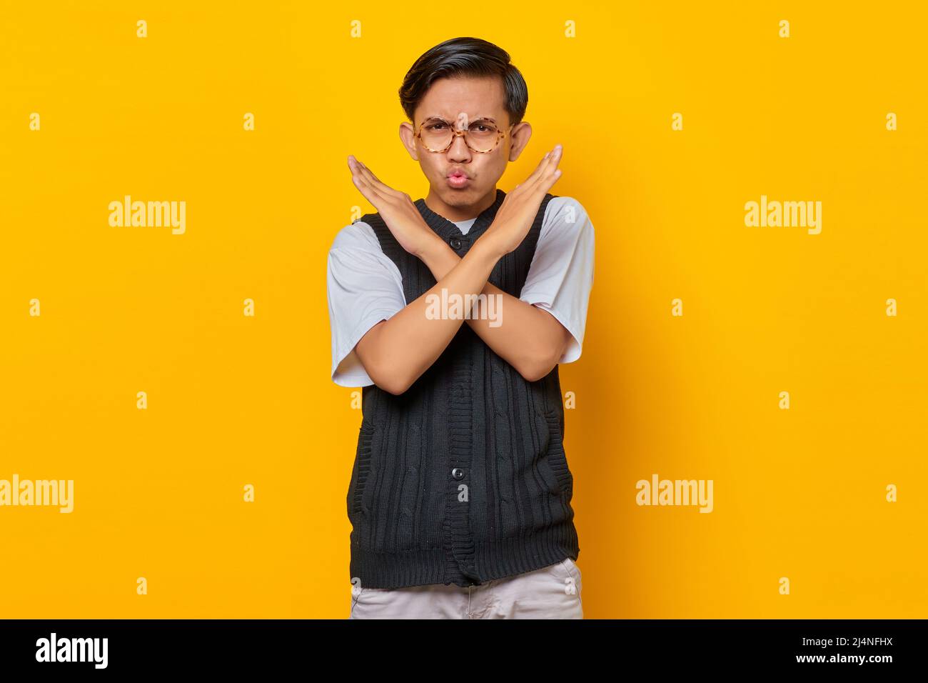 Serious young Asian man showing refusal gesture with crossed arms ...