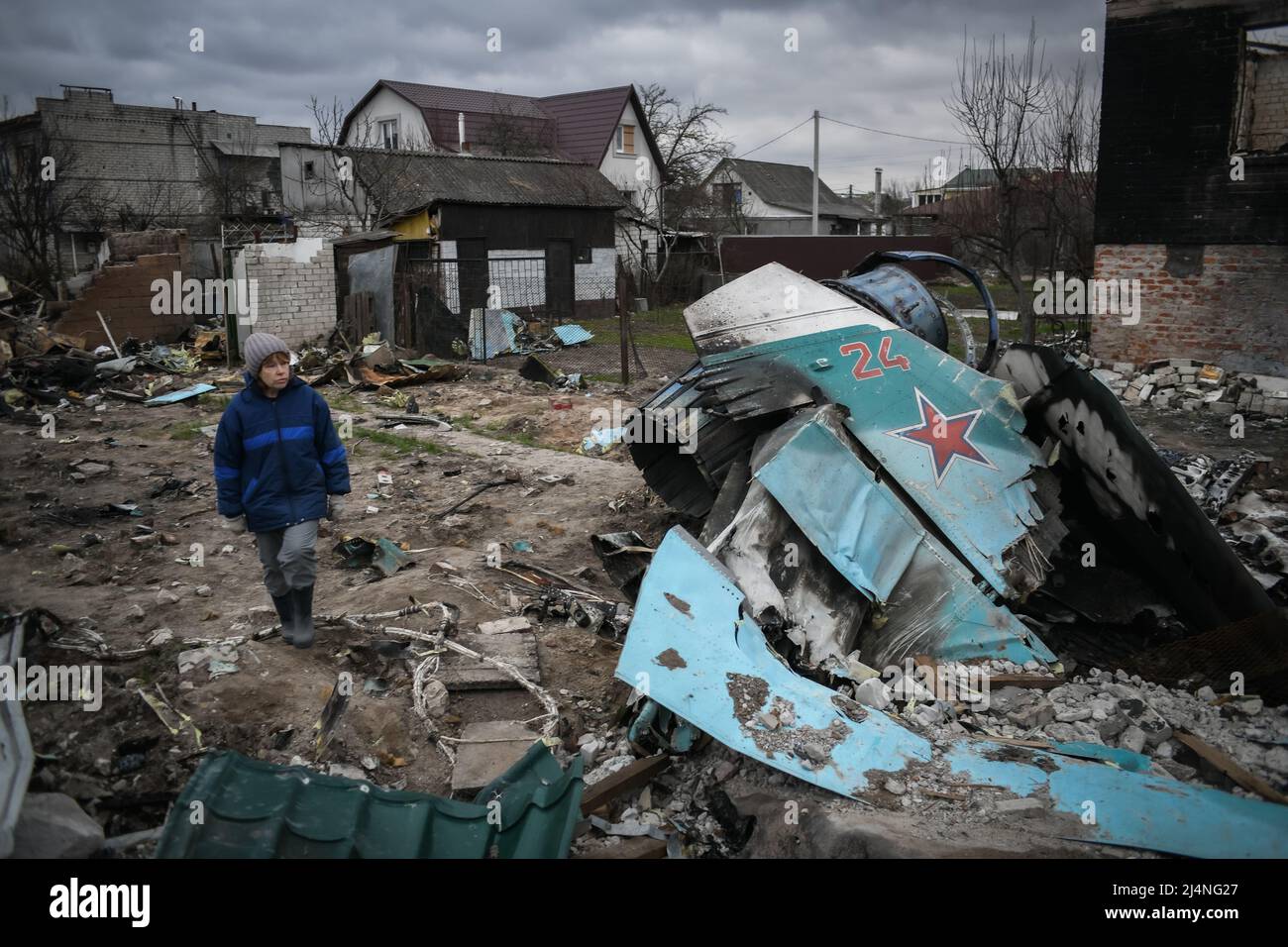A woman walks on rubbles on the site where a destroyed Russian Sukhoi ...