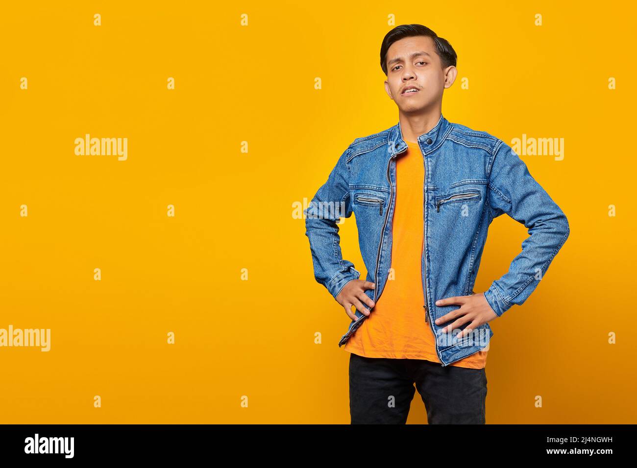 Portrait of confused asian man looking ahead on yellow background Stock ...