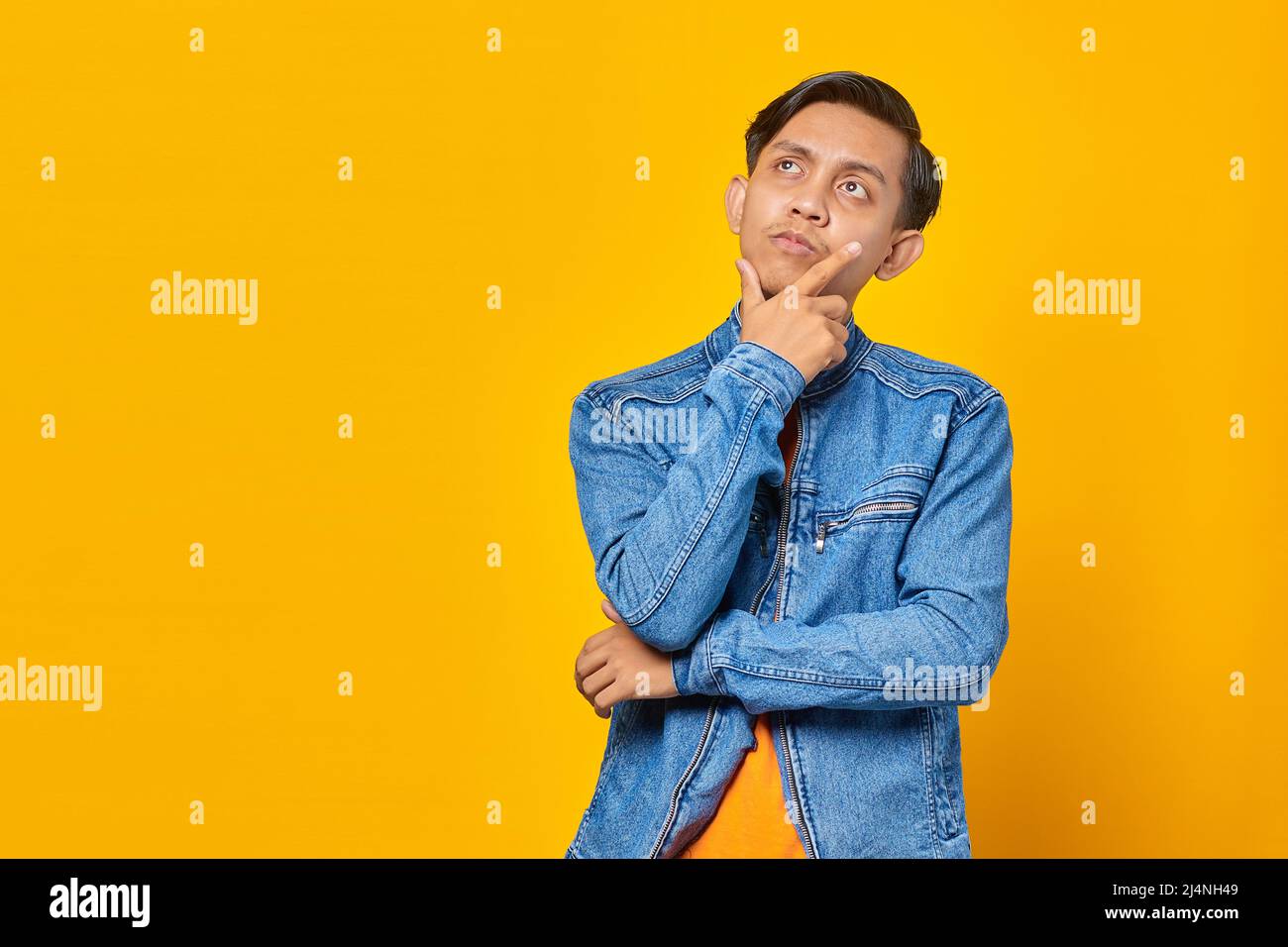 portrait of attractive young asian man holding ching with raised hand ...