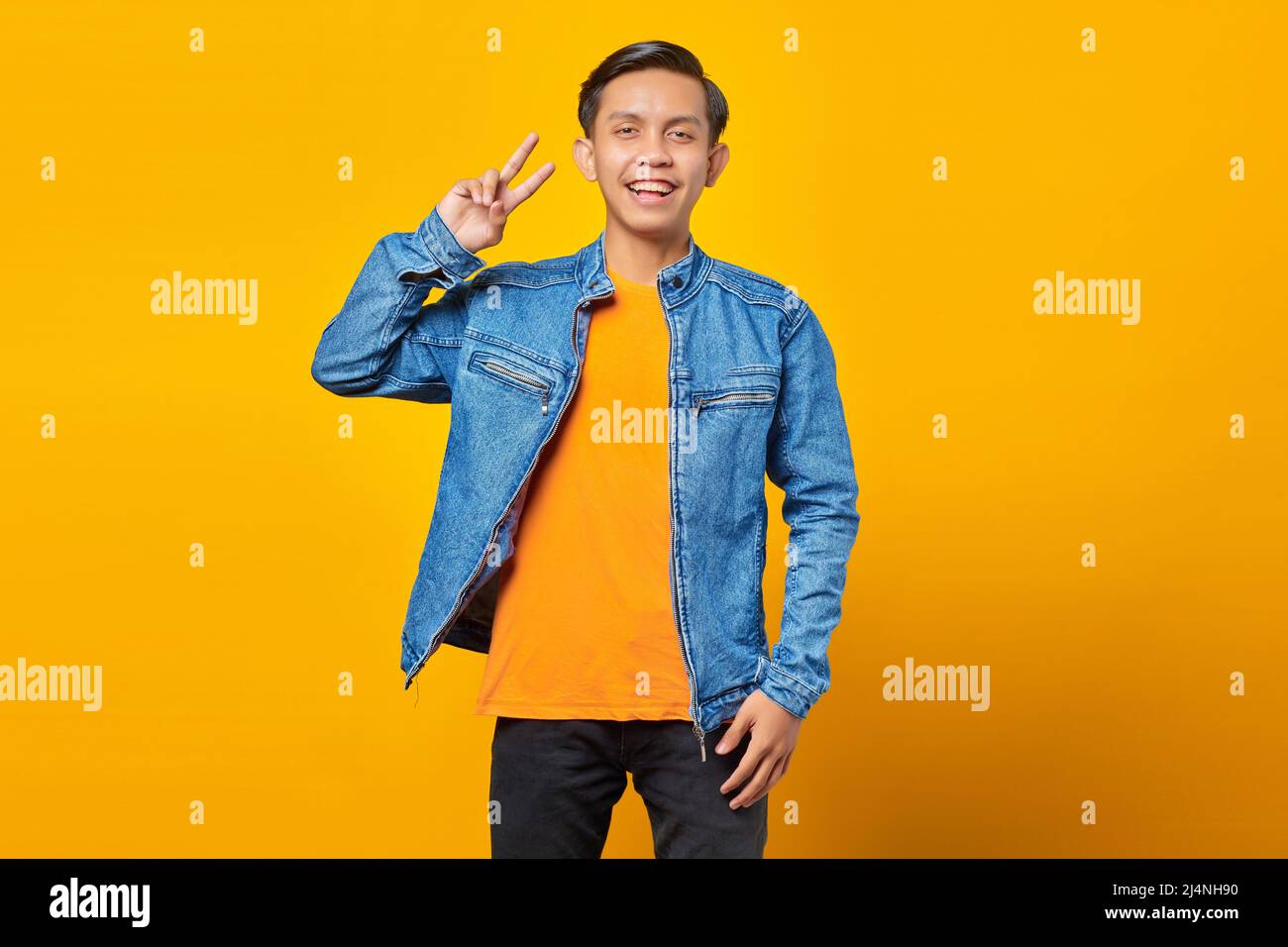 Attractive smiling young Asian man doing peace sign with hand Stock ...