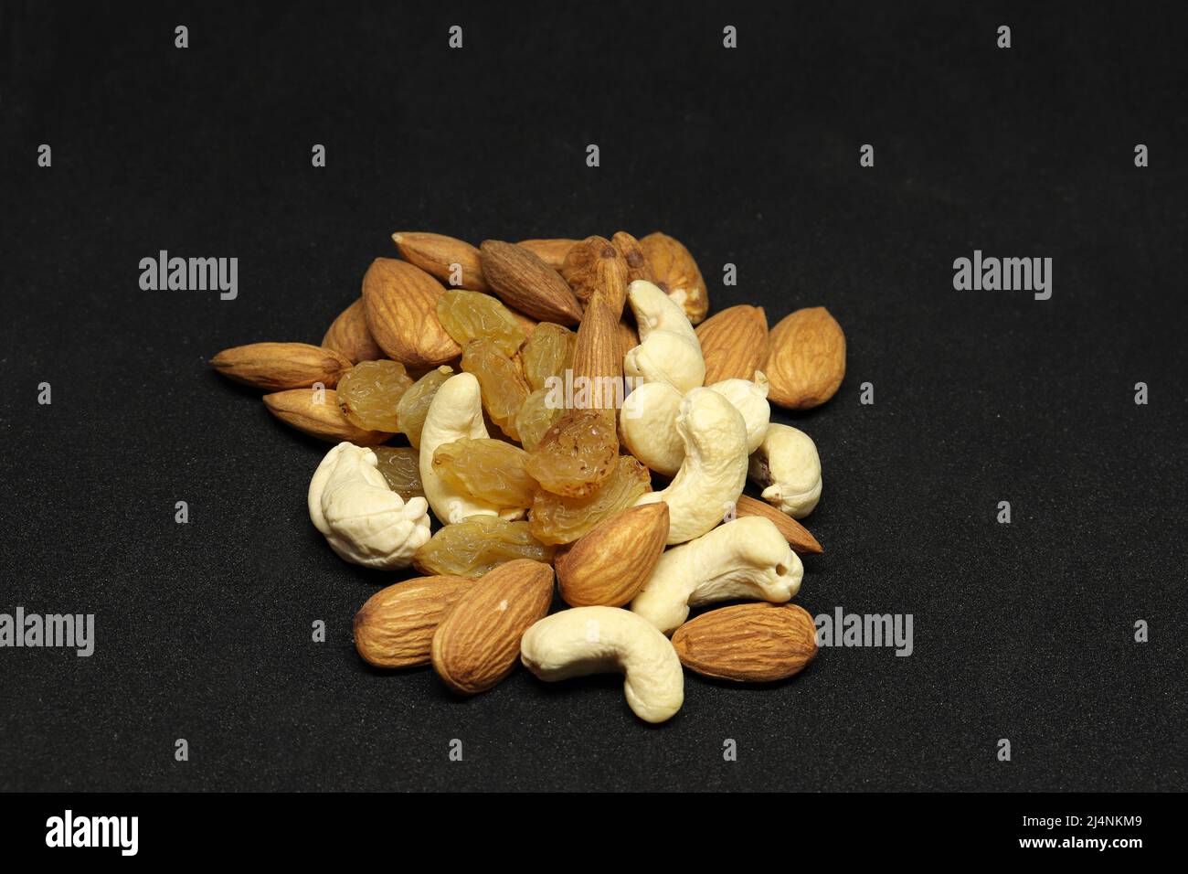 The Healthy Dry Fruit Almond Cashews And Grapes On A Black