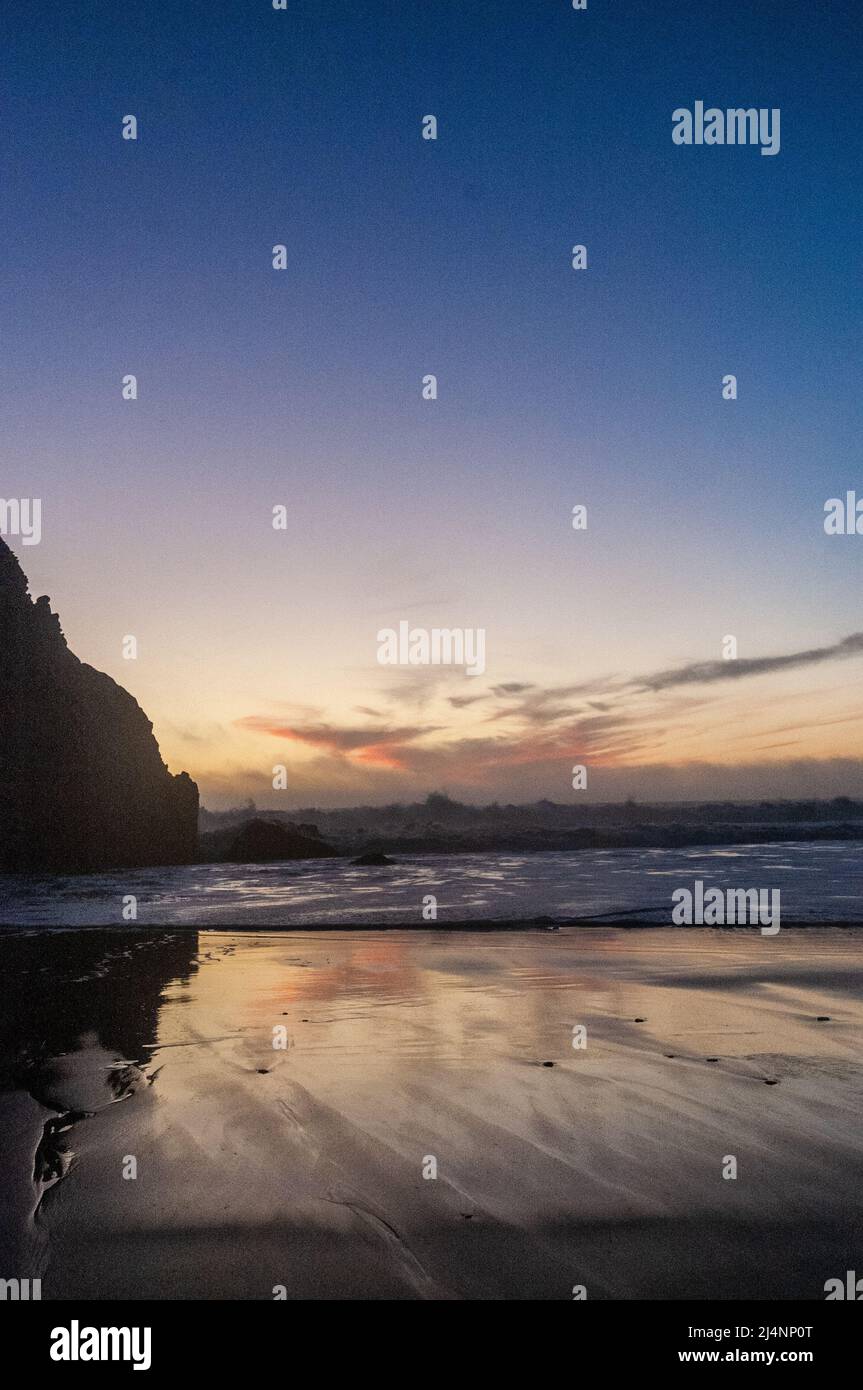 Rocks in the surf of Pfeiffer beach, around sunset. Deep yellow orange ...